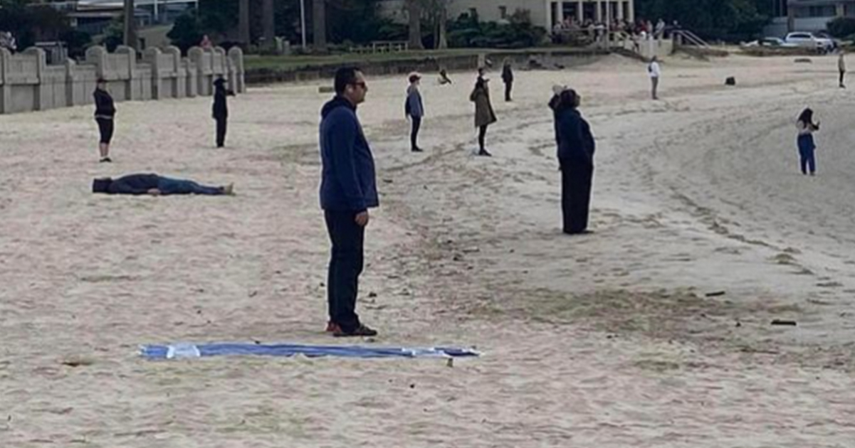 Woman snaps eerie photo of "zombie" people standing frozen on beach ...